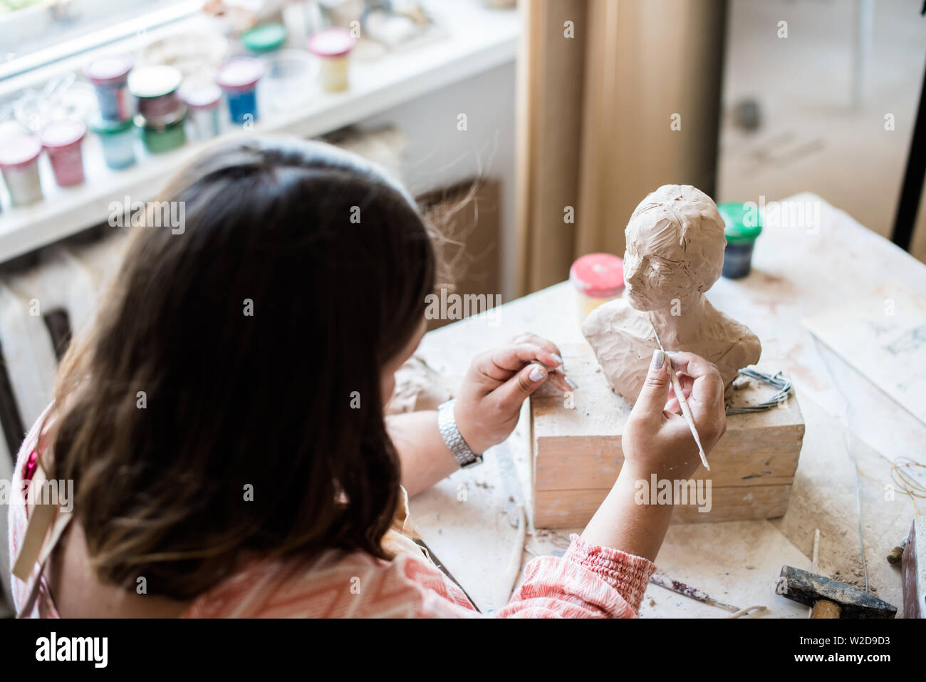 Lady sculptor working in her studio, ceramis artist's hands making ...