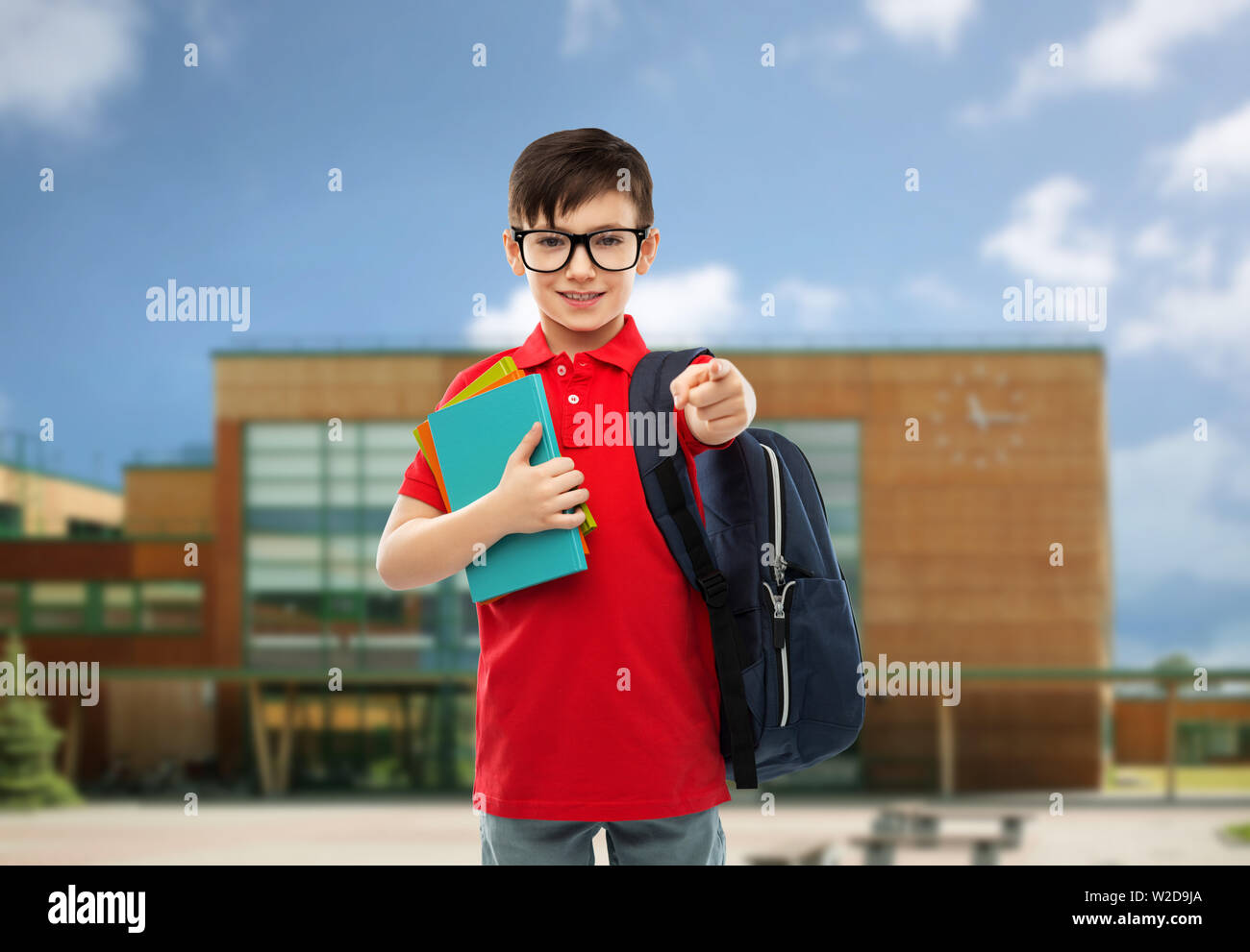 schoolboy with books and bag over school Stock Photo - Alamy