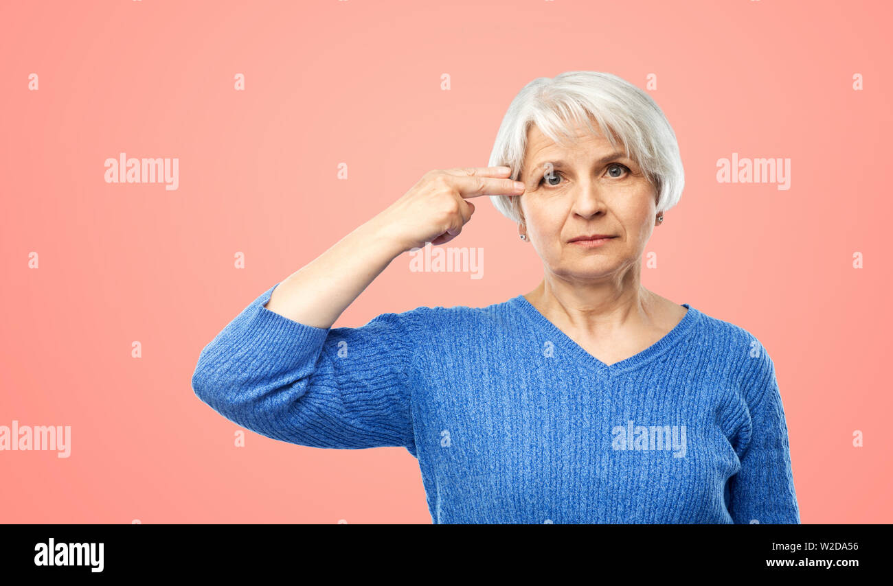 senior woman making finger gun gesture Stock Photo - Alamy