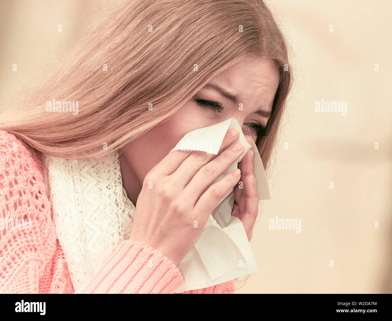 Sick woman in fall autumn park sneezing in tissue. Ill girl caught cold ...
