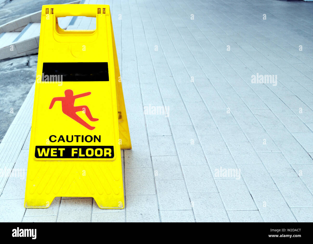 Yellow warning sign that says that the floor is slippery Stock Photo ...