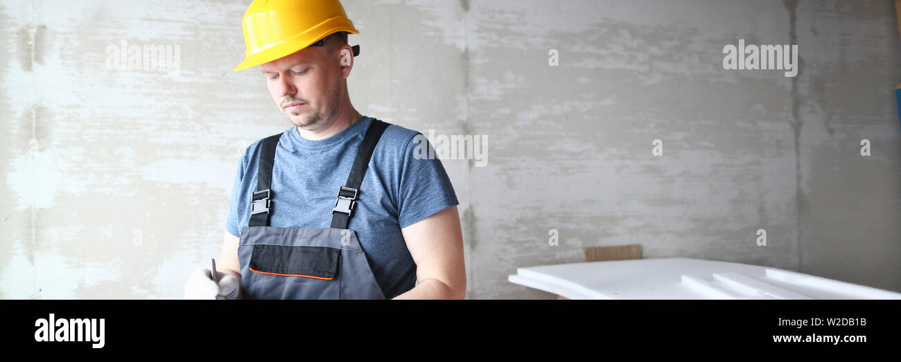 Male builder in yellow hard hat holds Stock Photo - Alamy