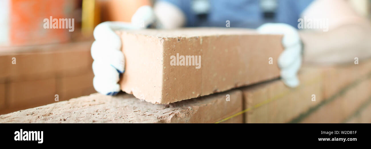 Male smiling builder puts make brickwork Stock Photo - Alamy