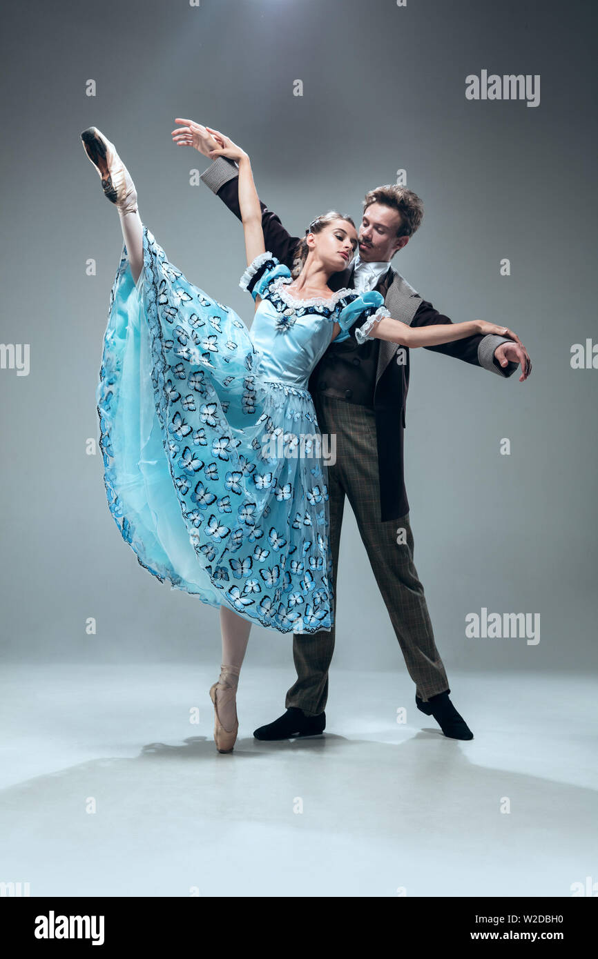 Free flight. Beautiful contemporary ballroom dancers isolated on grey ...