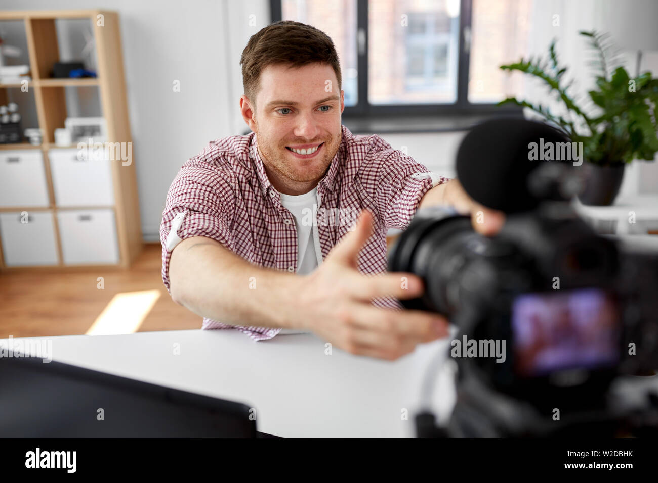 male video blogger adjusting camera at home office Stock Photo - Alamy