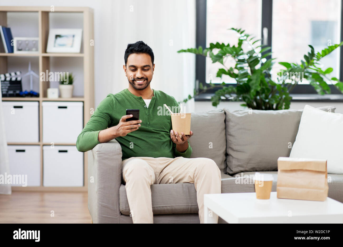 smiling indian man eating takeaway food at home Stock Photo - Alamy