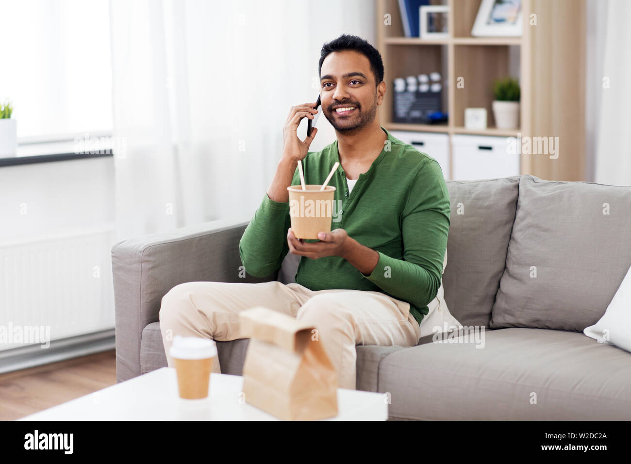 smiling indian man eating takeaway food at home Stock Photo - Alamy
