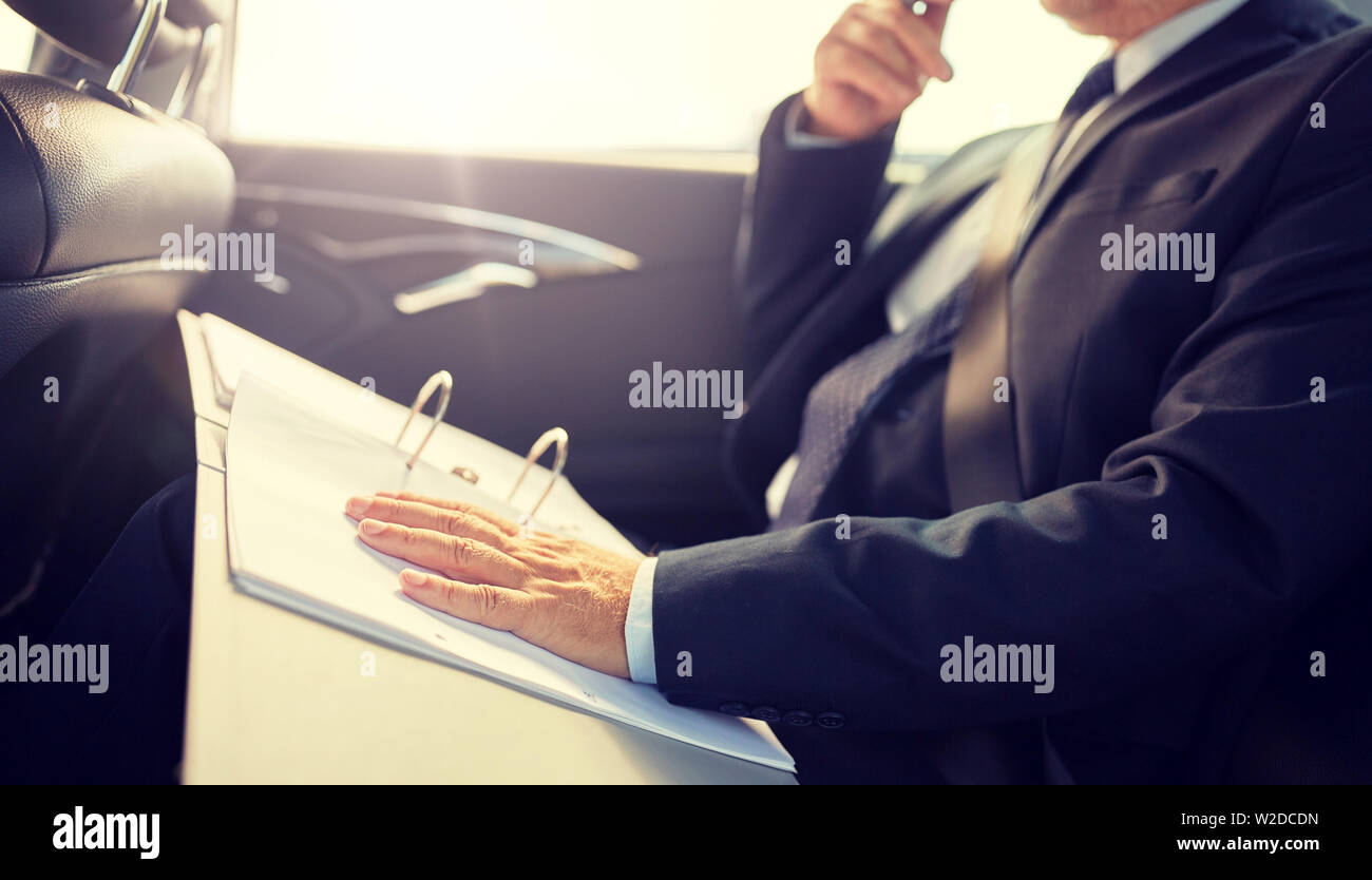 senior businessman with papers driving in car Stock Photo - Alamy