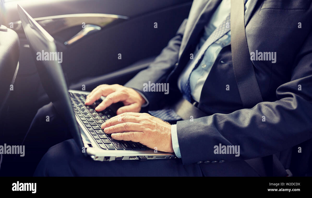 senior businessman with laptop driving in car Stock Photo - Alamy