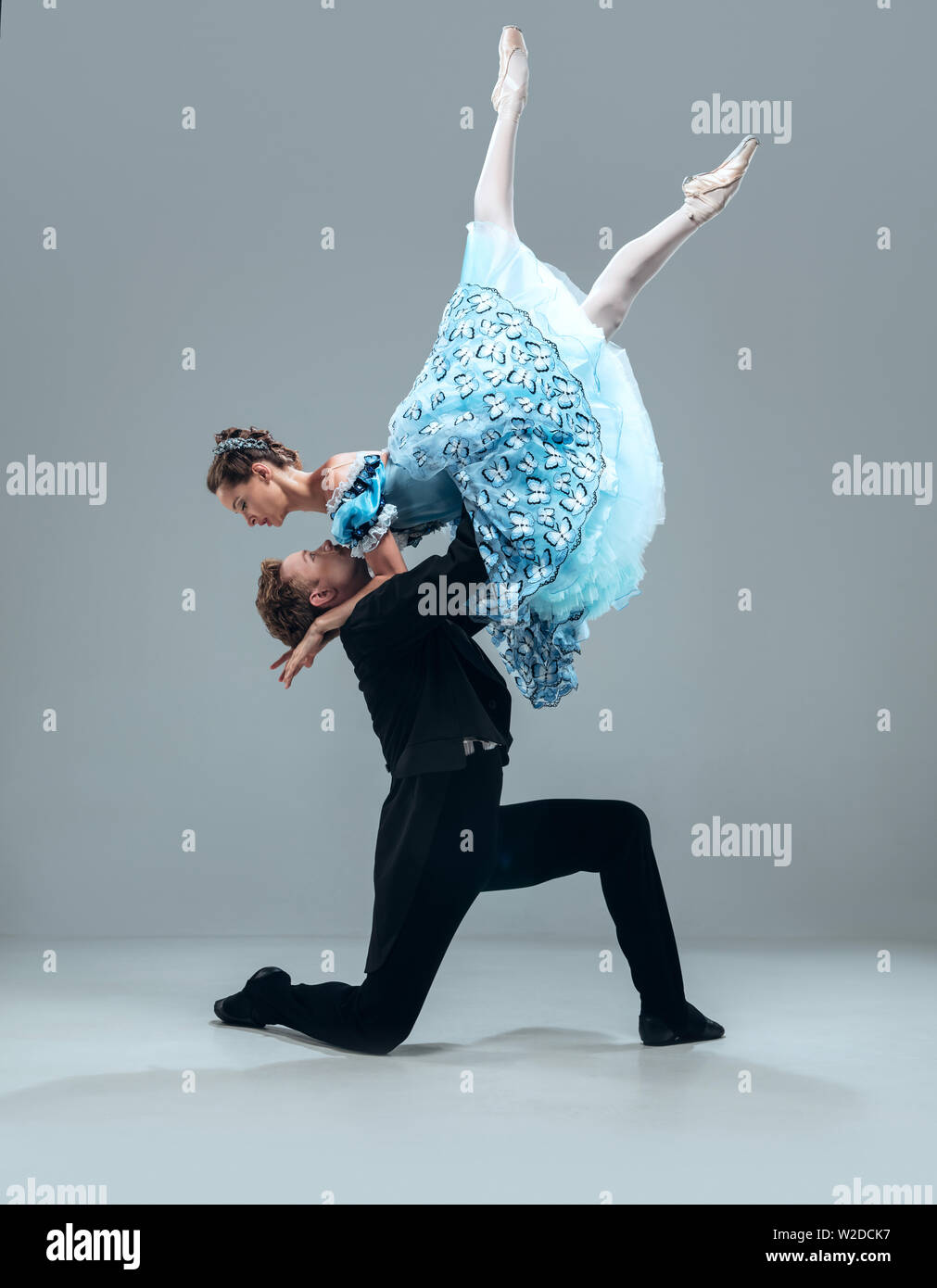 Like a cloud. Beautiful contemporary ballroom dancers isolated on grey ...