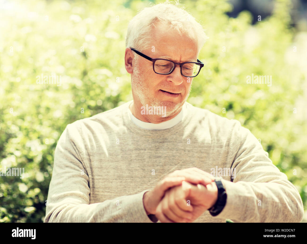 senior man checking time on his wristwatch Stock Photo - Alamy