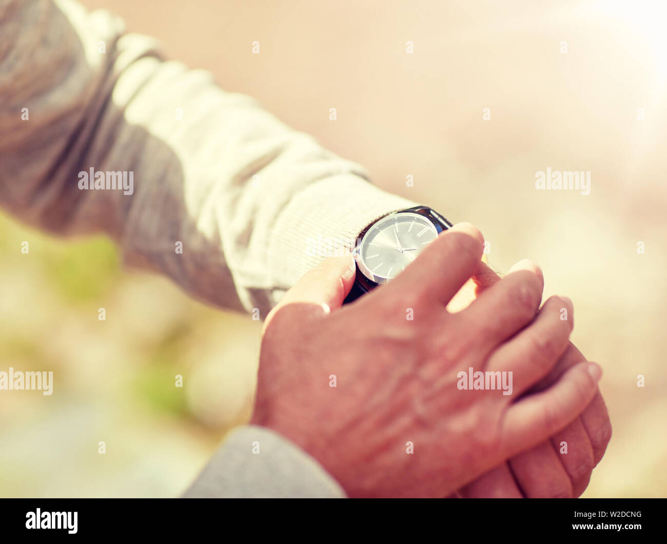 senior man checking time on wristwatch outdoors Stock Photo - Alamy