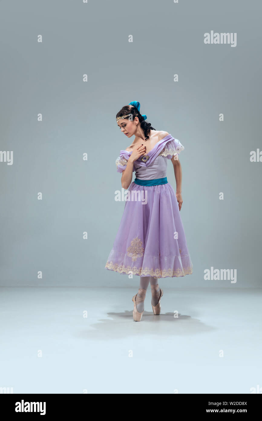 Embarrassment. Beautiful contemporary ballroom dancer isolated on grey ...