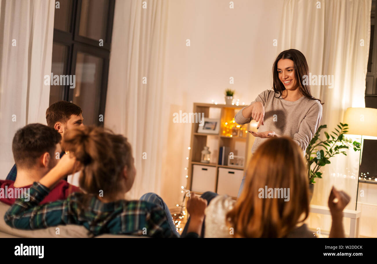 happy friends playing charades at home in evening Stock Photo - Alamy