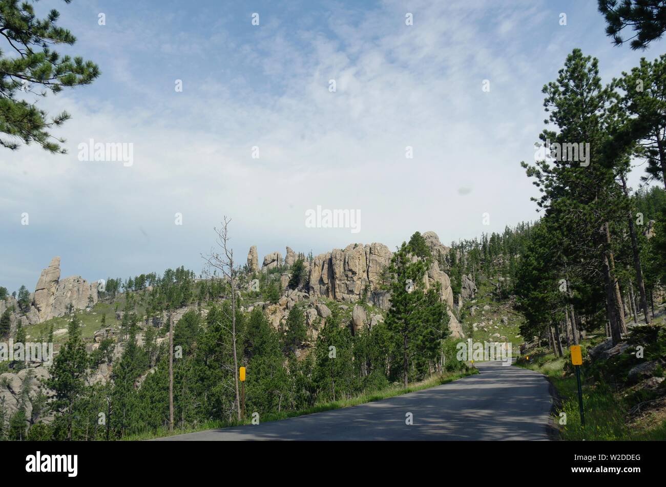Wide scenic drive along a winding road with dramatic granite formations ...