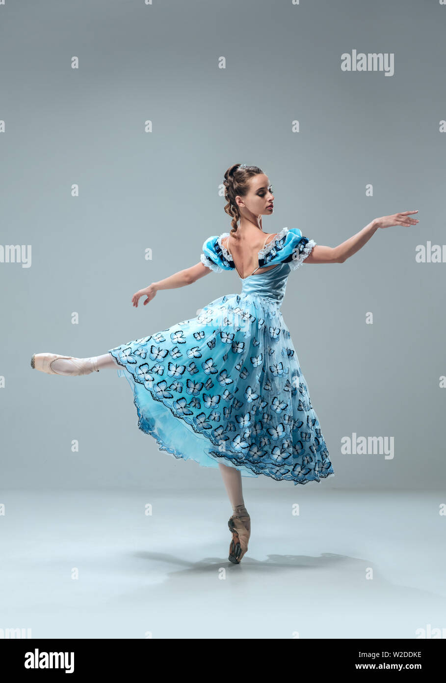 Light moving. Beautiful contemporary ballroom dancer isolated on grey ...