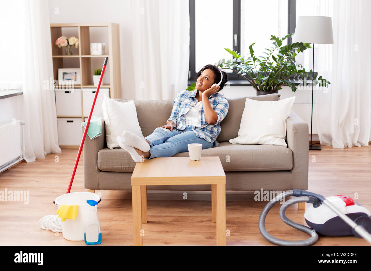 woman in headphones resting after home cleaning Stock Photo - Alamy