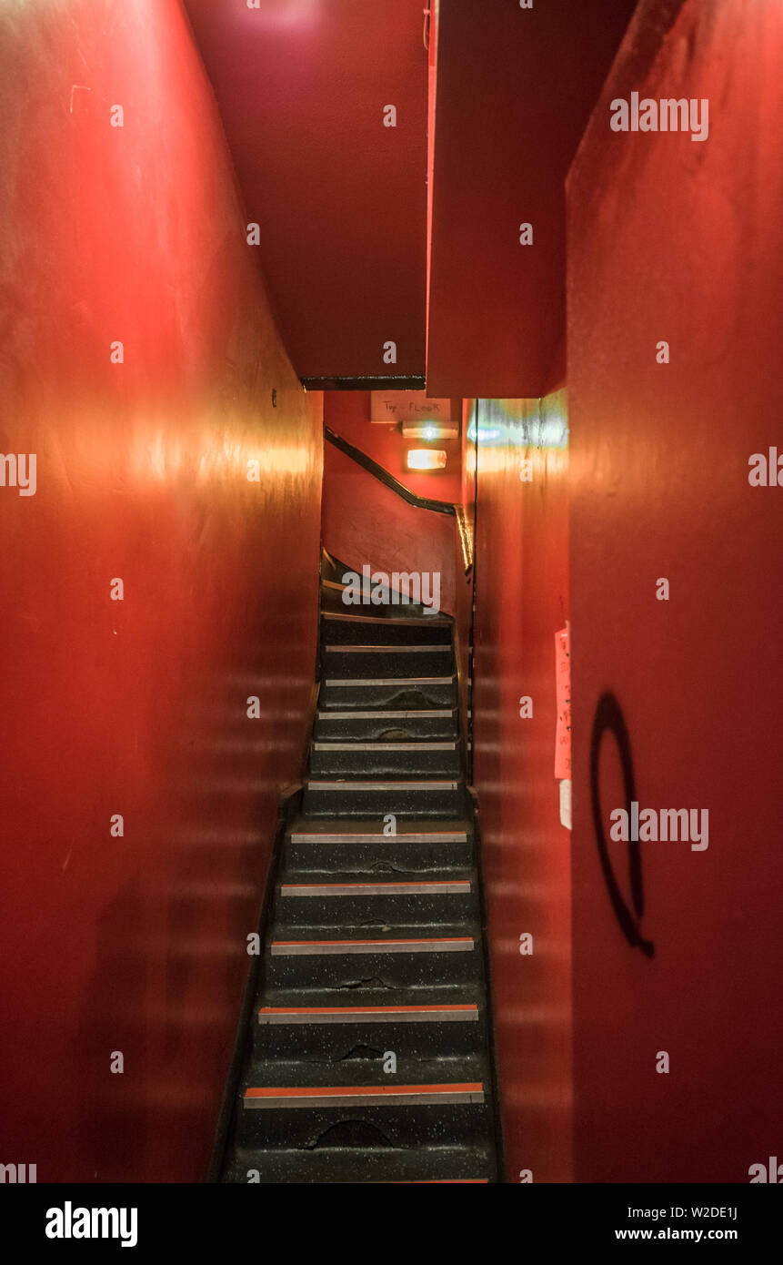 Red, gloomy seedy staircase Stock Photo - Alamy