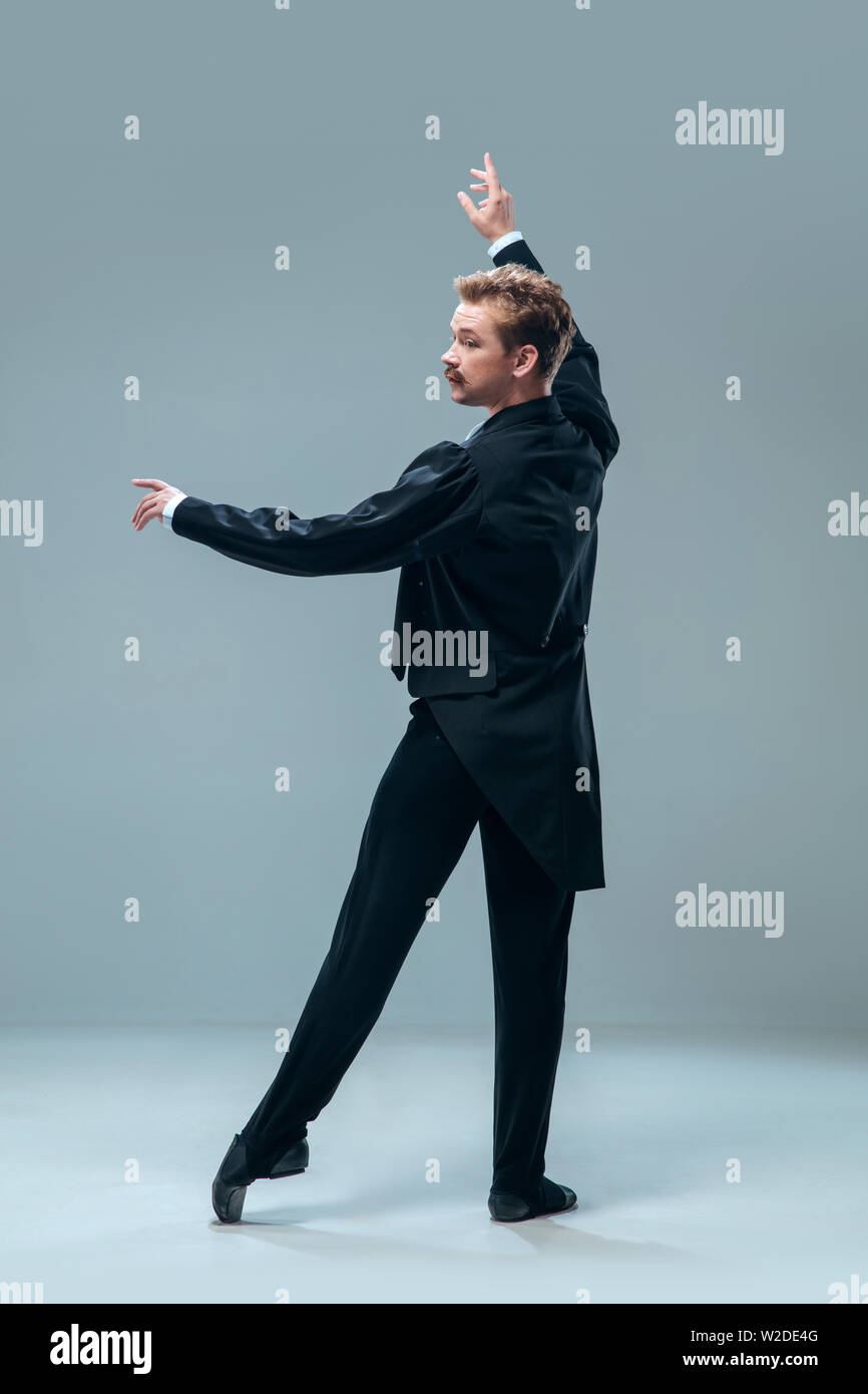 Looking back. Beautiful contemporary ballroom dancer isolated on grey ...