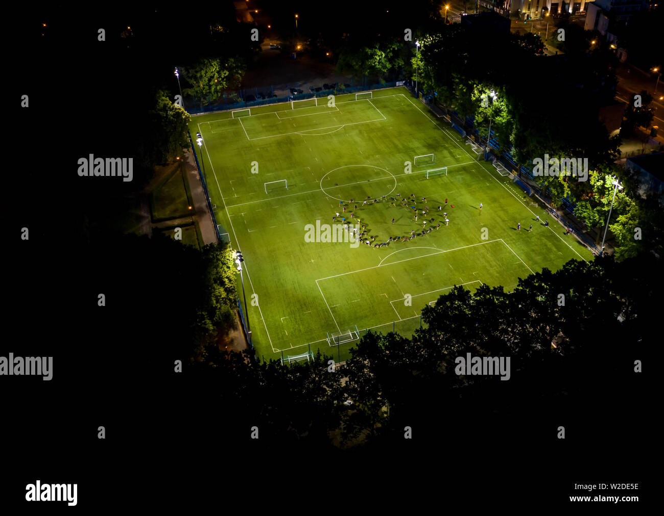Aerial view of football pitch at night with amateur football players ...