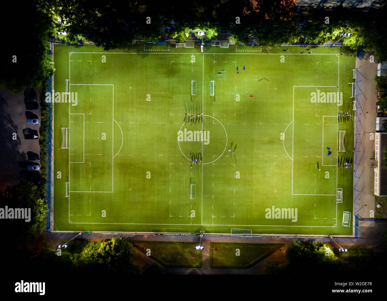 Aerial view of football pitch at night with amateur football players ...