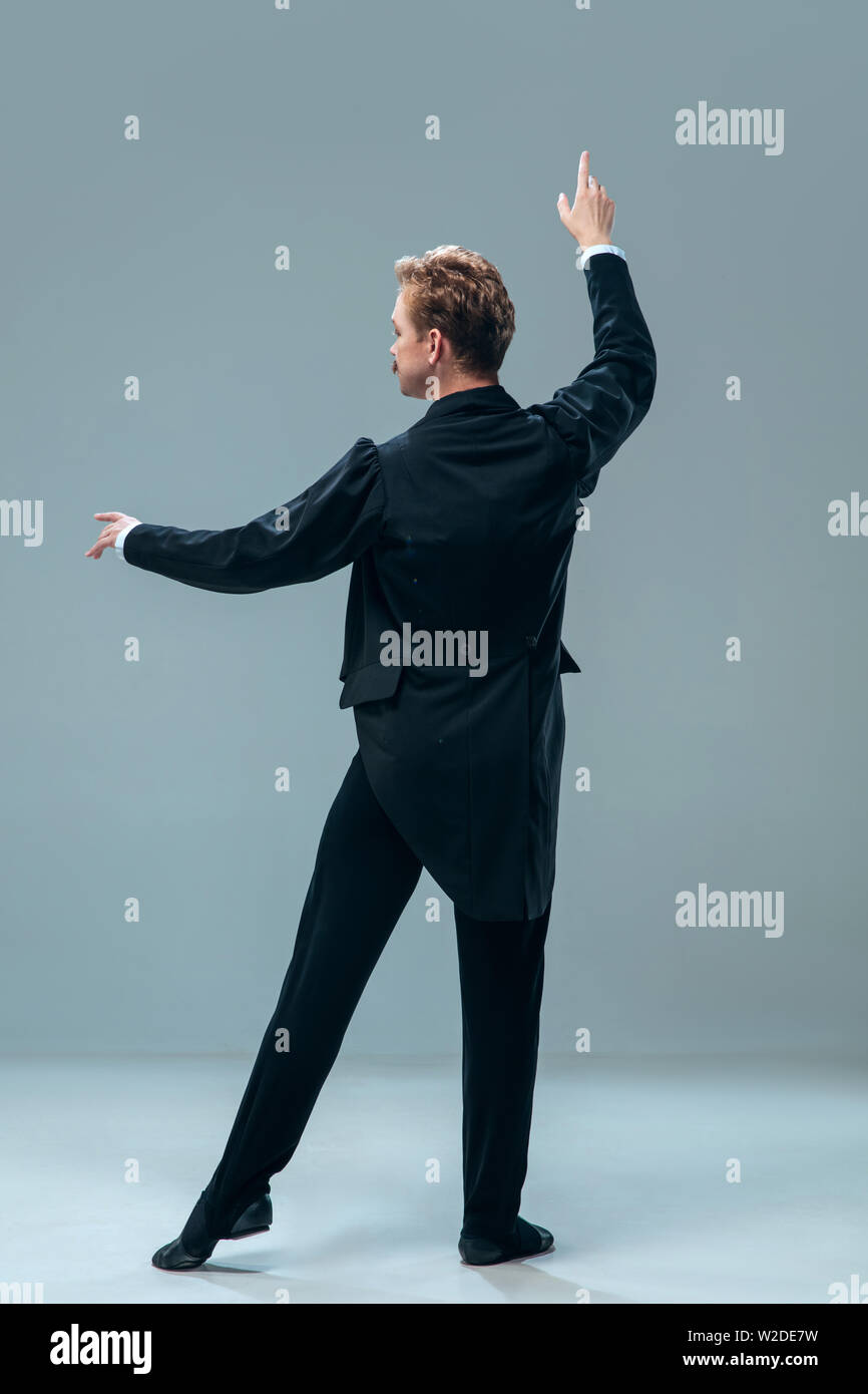Just a moment. Beautiful contemporary ballroom dancer isolated on grey ...