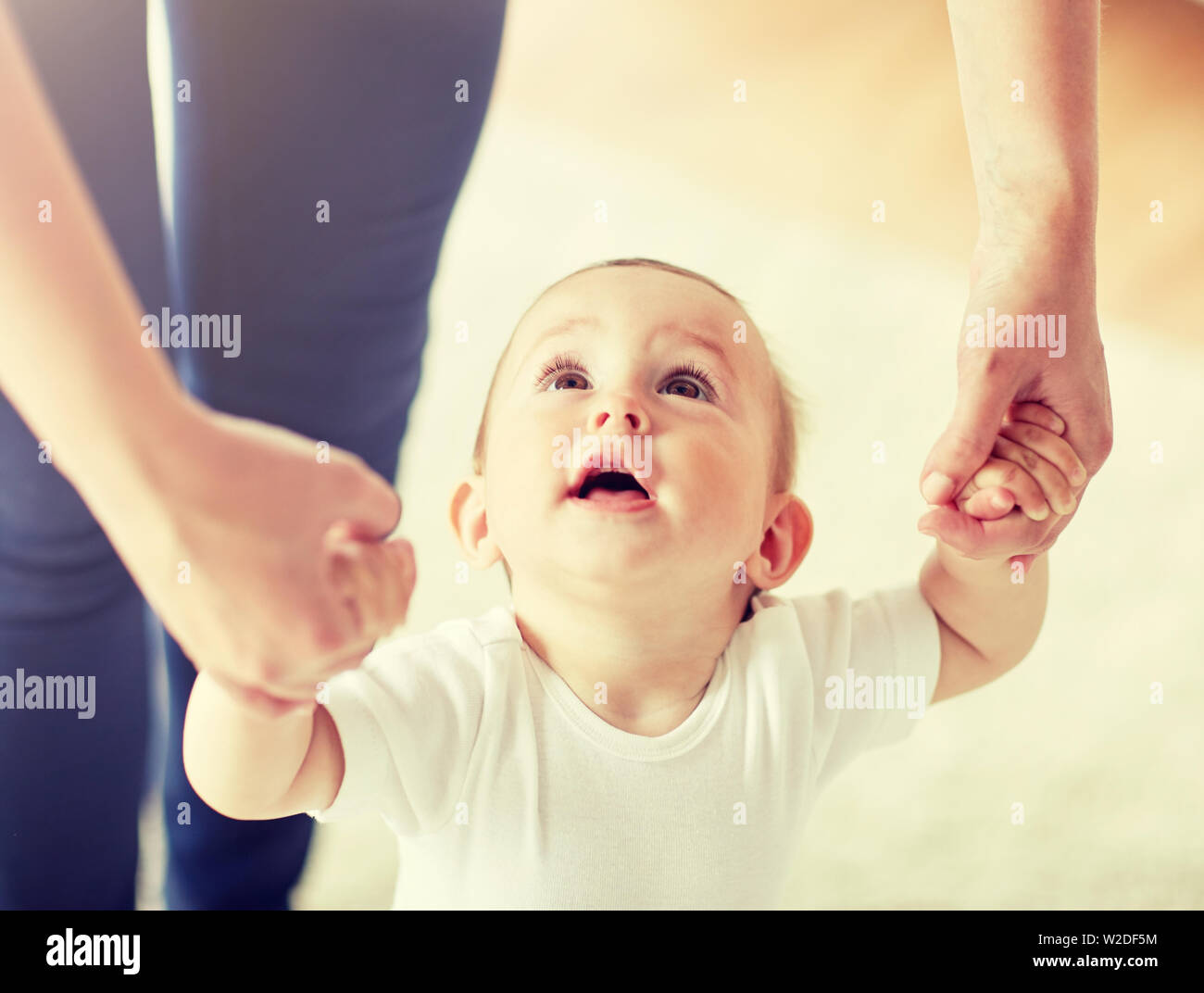 happy baby learning to walk with mother help Stock Photo - Alamy