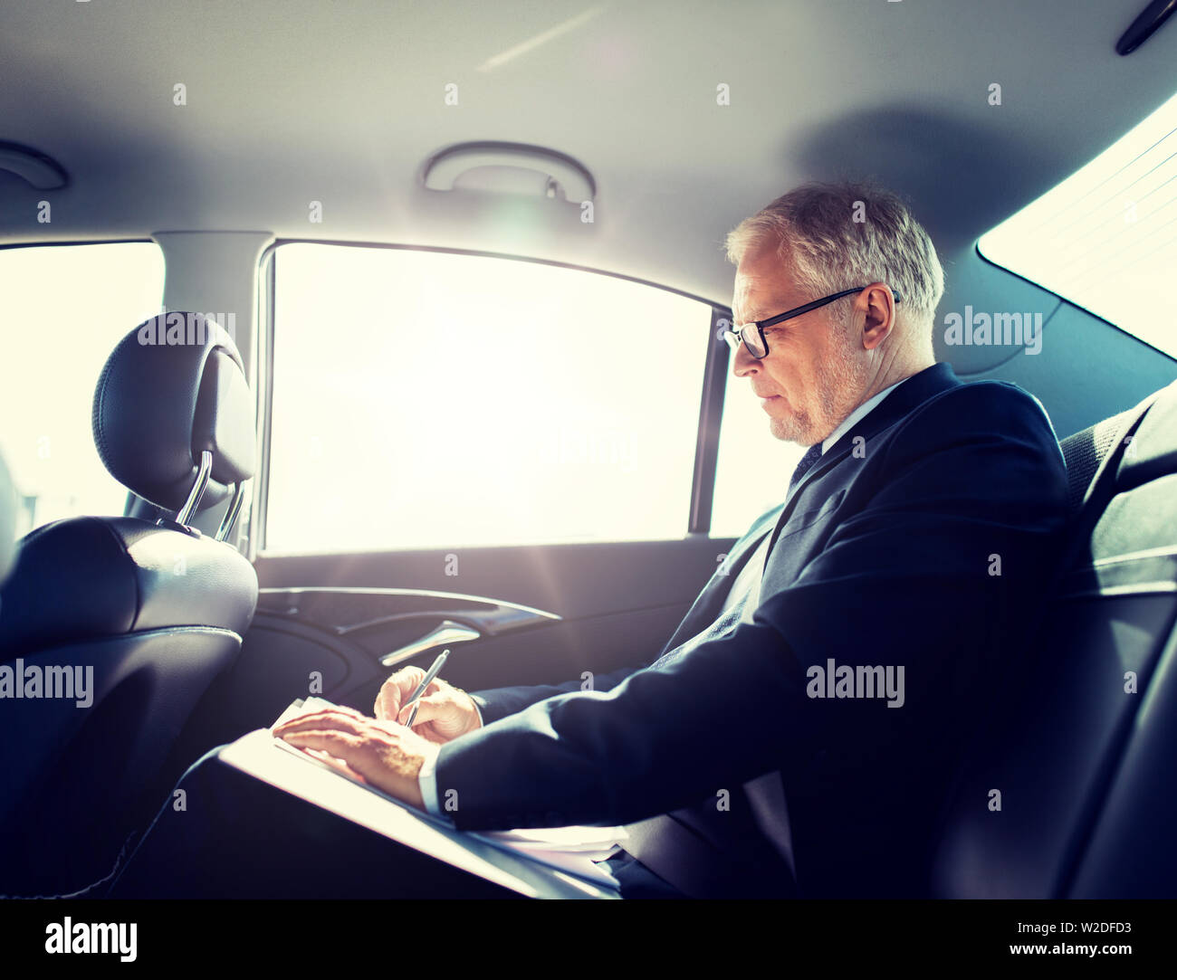 senior businessman with papers driving in car Stock Photo - Alamy