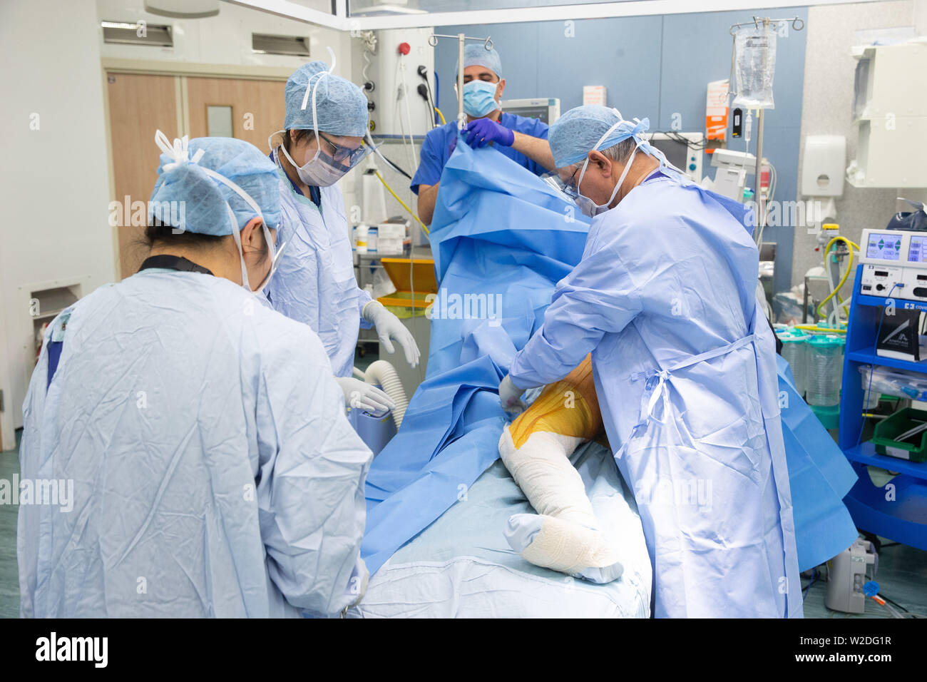 A surgeon and Nurses prepare a patient for surgery in an operating ...