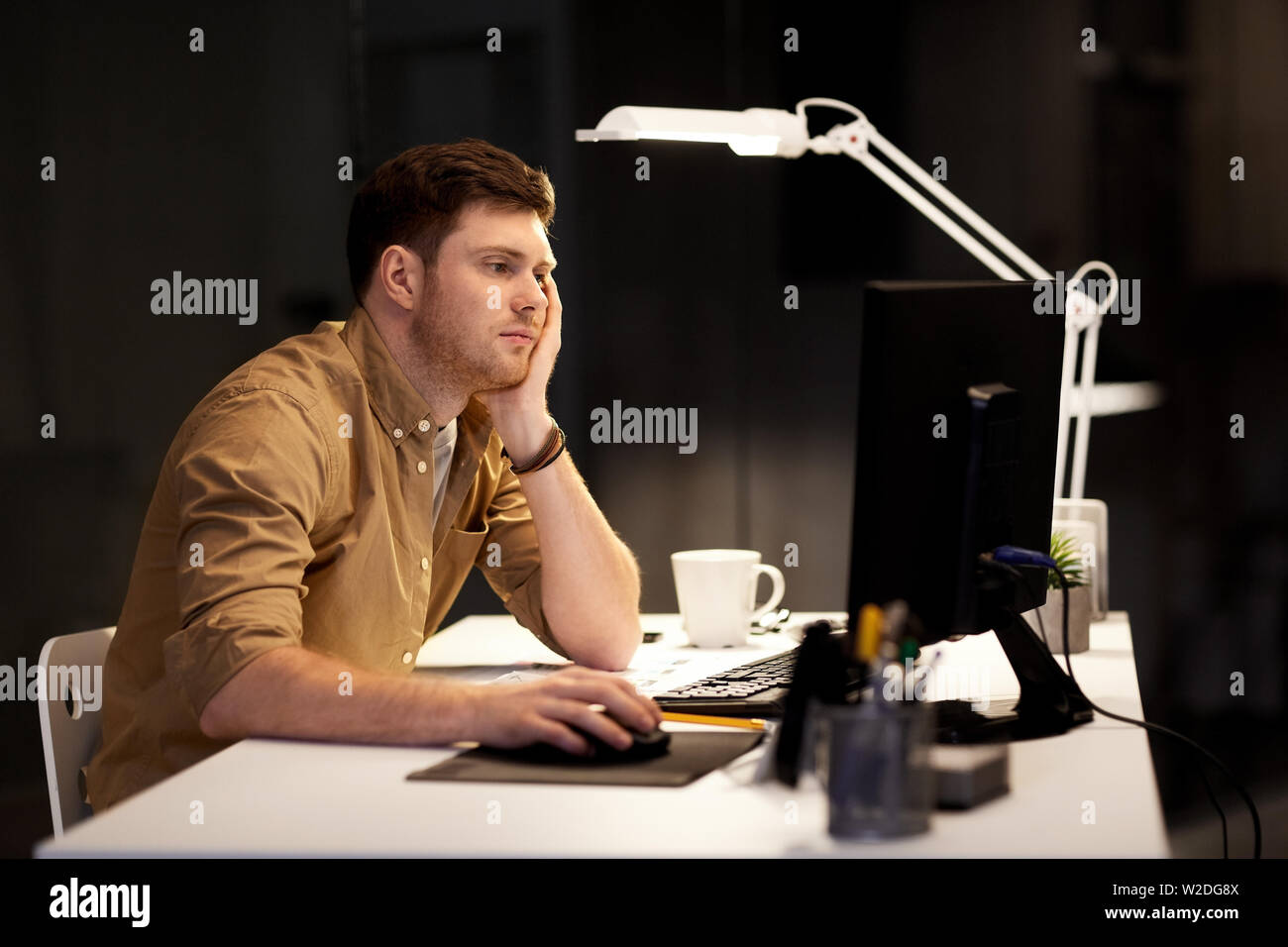 tired or bored man working late at night office Stock Photo - Alamy