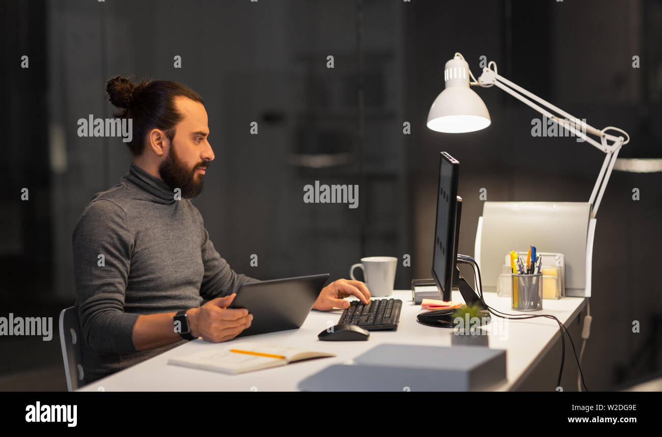 creative man with computer working at night office Stock Photo - Alamy