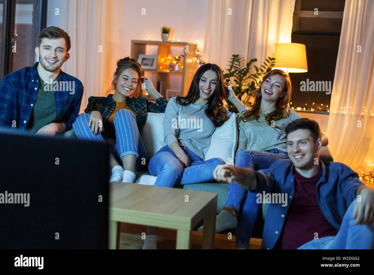 happy friends watching tv at home in evening Stock Photo - Alamy