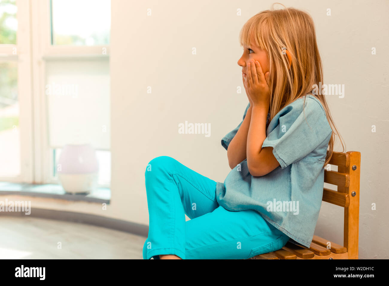 Nice cute girl sitting on the chair Stock Photo - Alamy
