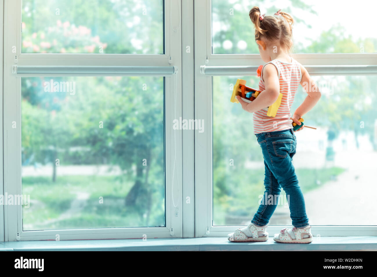 Nice young girl looking into the window Stock Photo - Alamy