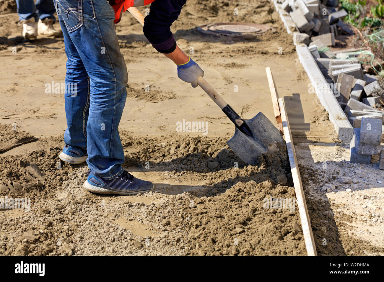 The worker aligns the foundation with sand and a shovel under the ...