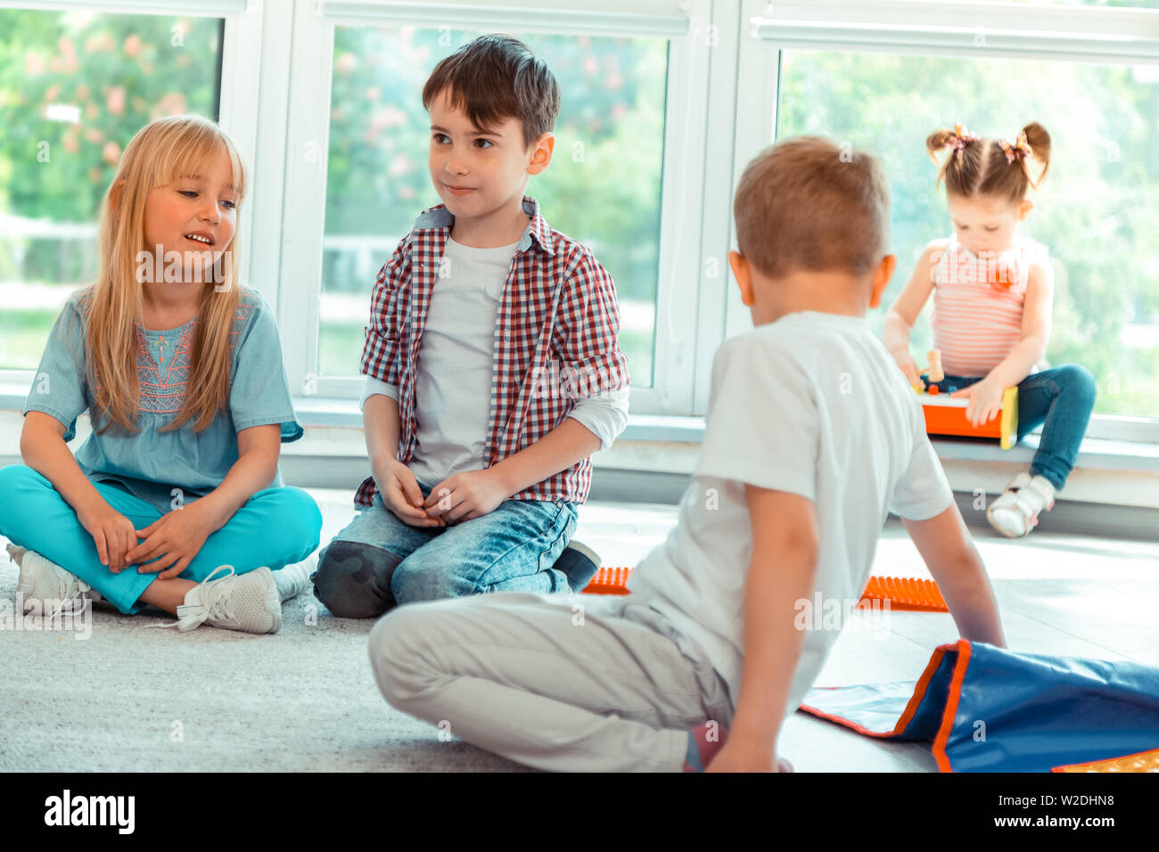 Nice pretty children sitting on the floor Stock Photo - Alamy