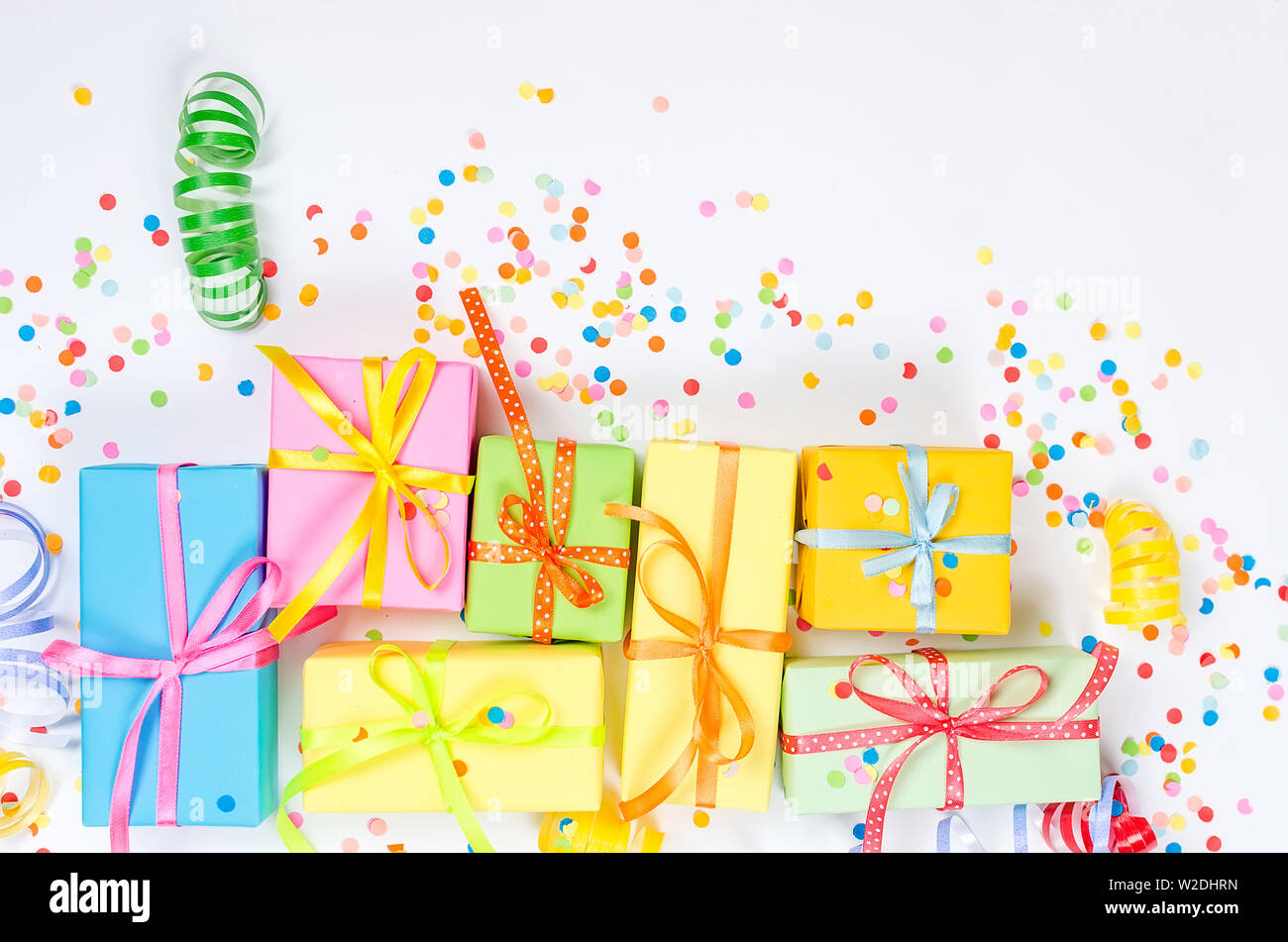 Colorful Gift boxes, paper confetti and twirled party serpentine on a ...