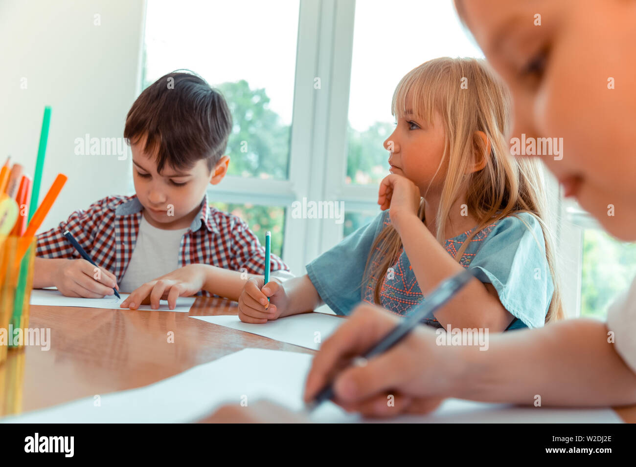 Nice thoughtful blonde girl drawing a picture Stock Photo - Alamy