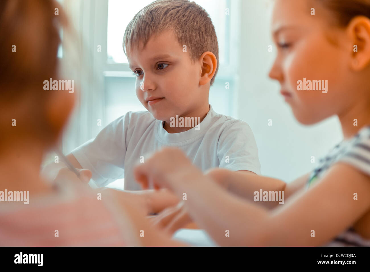 Nice cute boy thinking about the art lesson Stock Photo - Alamy