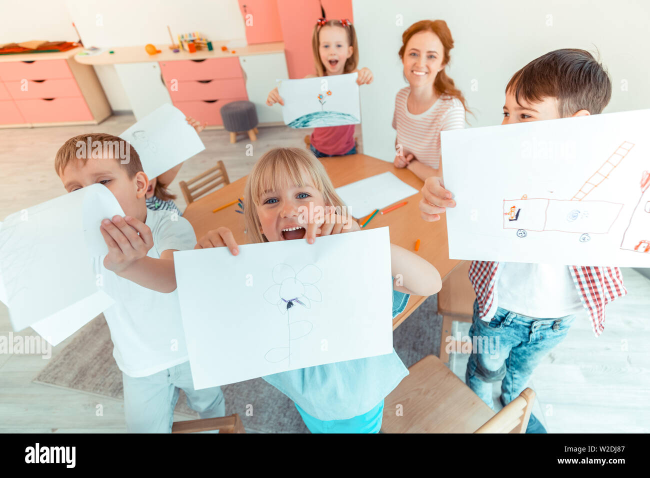 Top view of happy positive children with drawings Stock Photo - Alamy