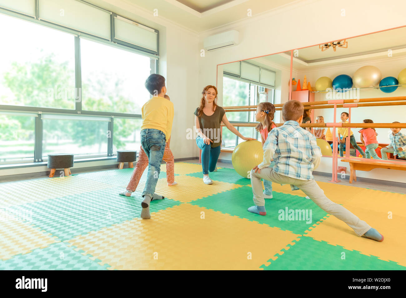 Nice pleasant kids doing different physical activities Stock Photo - Alamy