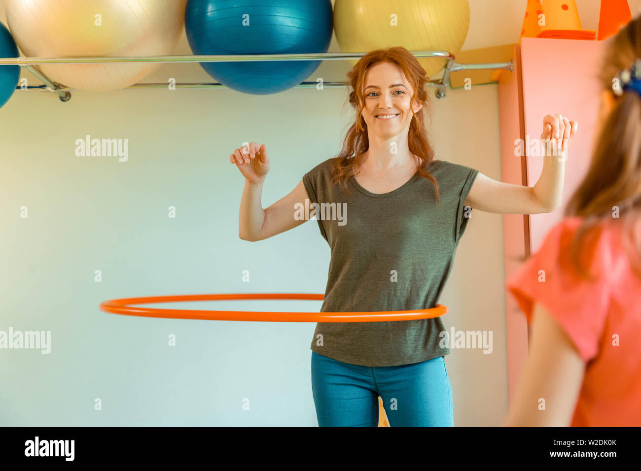 Happy positive woman rotating a hula hoop Stock Photo - Alamy