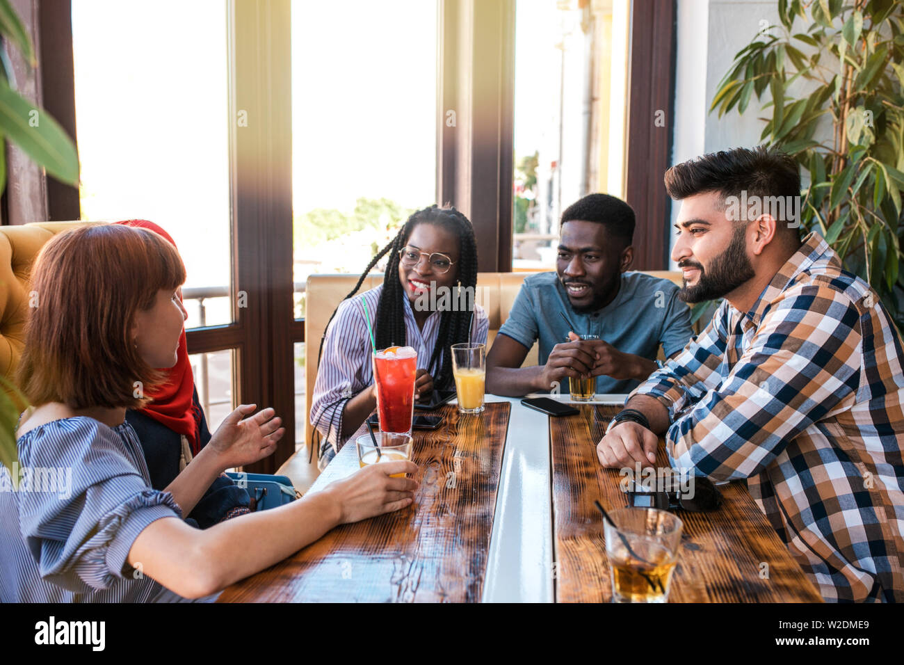Group of happy friends drinking juice and lemonade at cafe Stock Photo ...