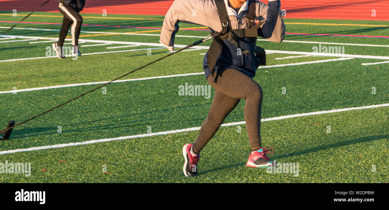 Athlets pulling weighted sleds at track and field speed training ...