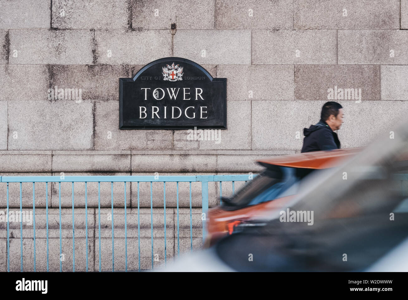 London, UK - June 22, 2019: Cars driving and man walking past the name ...