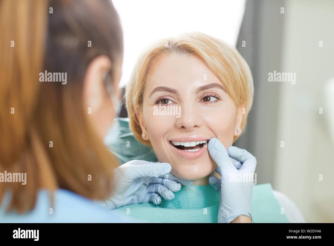 Dentist checks the tooth of a happy girl patient in a dental clinic Stock Photo - Alamy