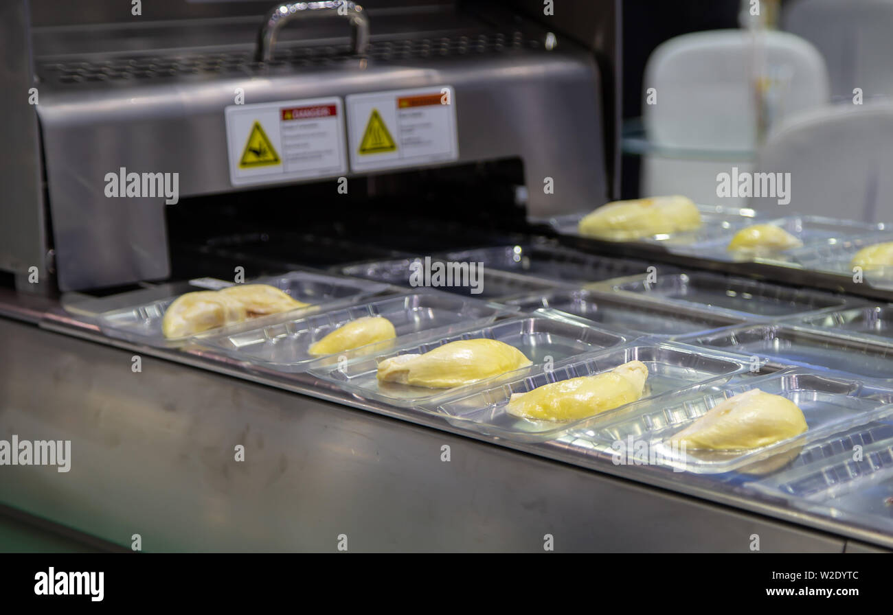 Durian on linear tray food heat sealing and packaging machine Stock ...