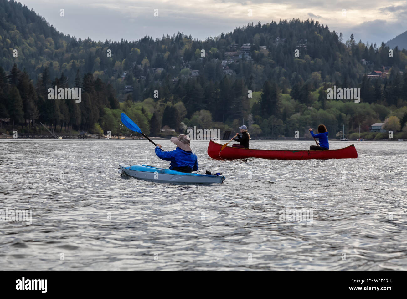 Adventurous friends on a red canoe and kayak are paddling in the Howe ...