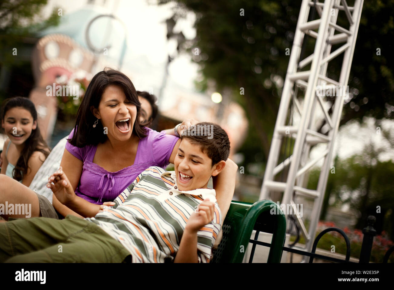 Laughing family sitting on a bench at an amusement park Stock Photo - Alamy