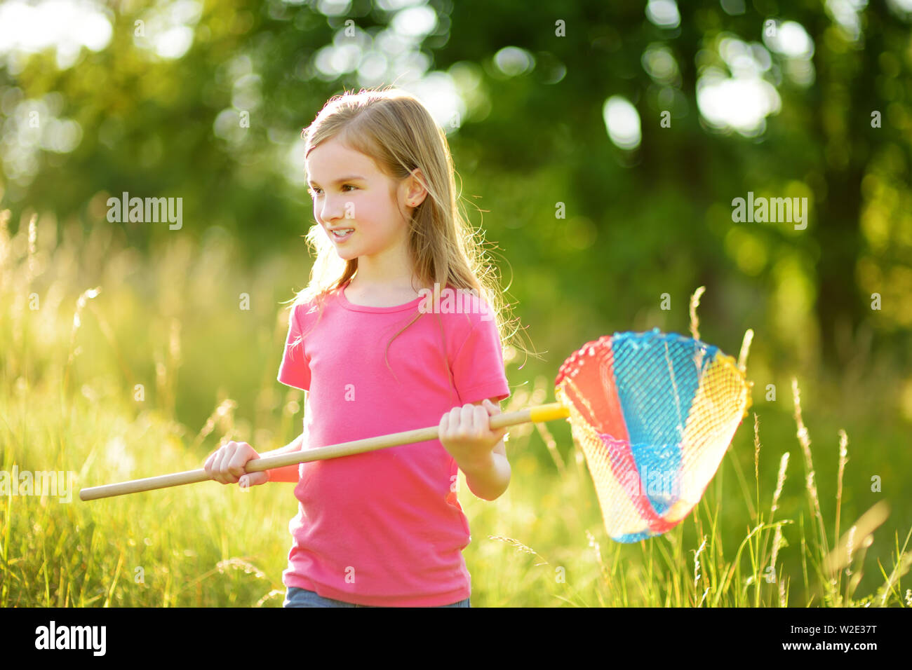 Adorable little girl catching butterflies and bugs with her scoop-net ...